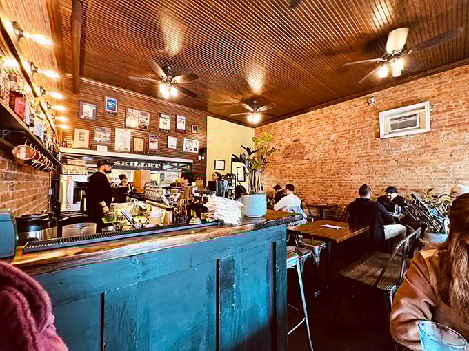 Exposed brick walls meet wooden ceilings in this cozy space where strangers become friends over coffee and conversations about what to order next.
