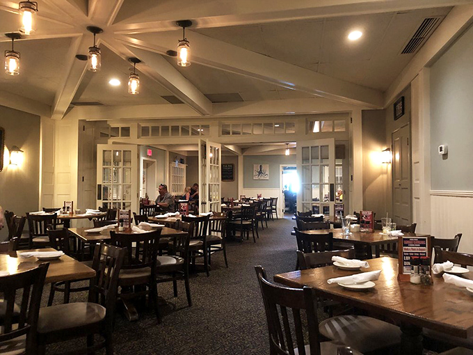 White wainscoting, exposed beams, and warm lighting create a dining room that feels like you've been transported to a cozy New England inn.