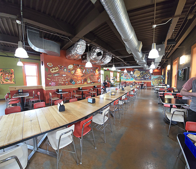 Inside, communal wooden tables and colorful walls create the perfect backdrop for the sandwich drama about to unfold on your plate.