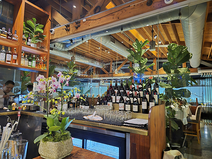 Exposed wooden beams and lush greenery create a warm, upscale ambiance where California casual meets culinary sophistication.