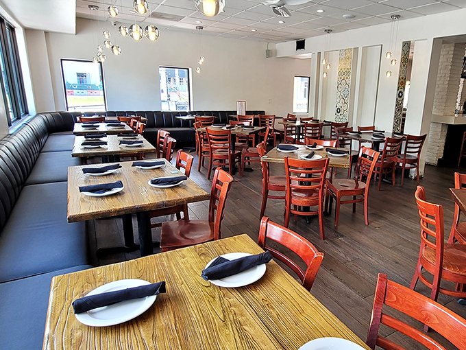 Modern elegance meets Cuban warmth in this dining room, where cherry-red chairs and blue banquettes create the perfect backdrop for culinary memories.
