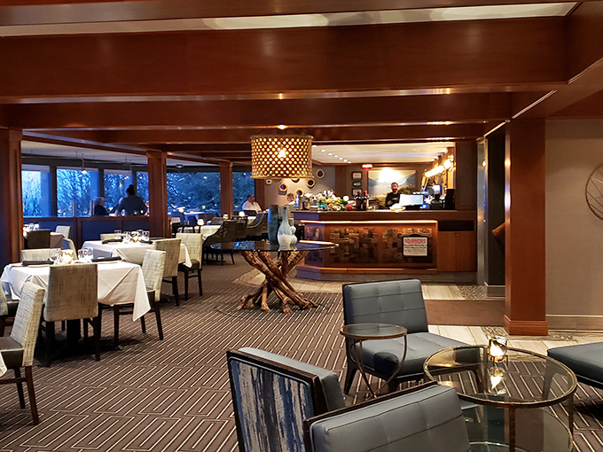 Warm wood tones, strategic lighting, and those floor-to-ceiling windows create the perfect backdrop for both the food drama and nature's show outside.