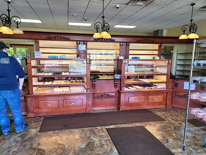 Classic wooden display cases and warm lighting create an atmosphere that says, "Calories don't count when they're this artisanal."