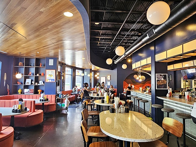 Step into a mid-century space fantasy where curved wooden ceilings, globe lights, and coral booths create an atmosphere that's equal parts nostalgia and tomorrow-land.