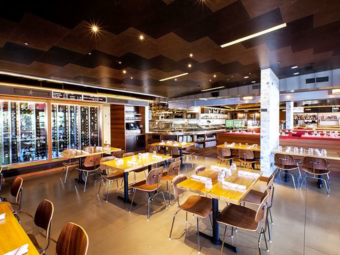 Inside, the undulating wooden ceiling mimics ocean waves while the open layout invites you to witness the seafood symphony. No secrets here, just pure culinary transparency.