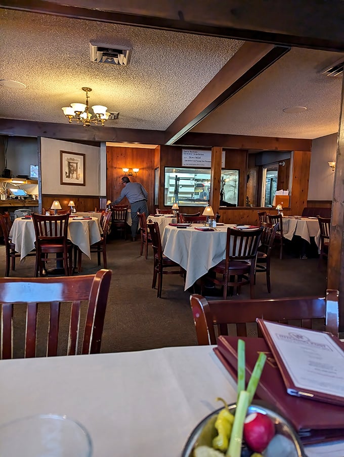 White tablecloths meet wood-paneled walls in this dining room where serious steak business happens. The open kitchen view is dinner and a show.
