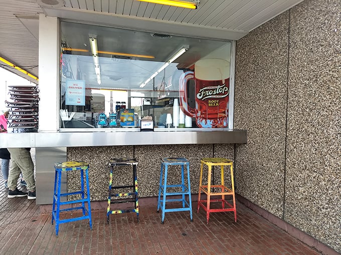Colorful stools await hungry patrons at the walk-up window, each one telling stories of countless summer evenings and satisfied customers.