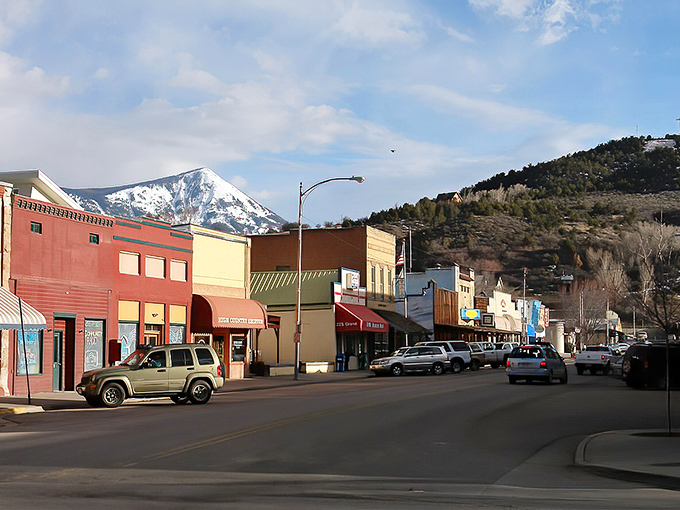 Grand Avenue stretches beneath the watchful gaze of Mount Lamborn, its colorful storefronts like a painter's palette against Colorado's blue sky.