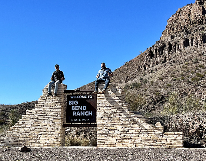 The entrance sign might as well say "Adventure Begins Here." Two visitors celebrate their arrival at Texas' best-kept secret.