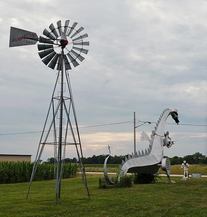 Rural Americana at its finest: a classic farm windmill stands sentinel beside the dragon, creating an only-in-the-Midwest tableau of agricultural tradition meets fantasy.
