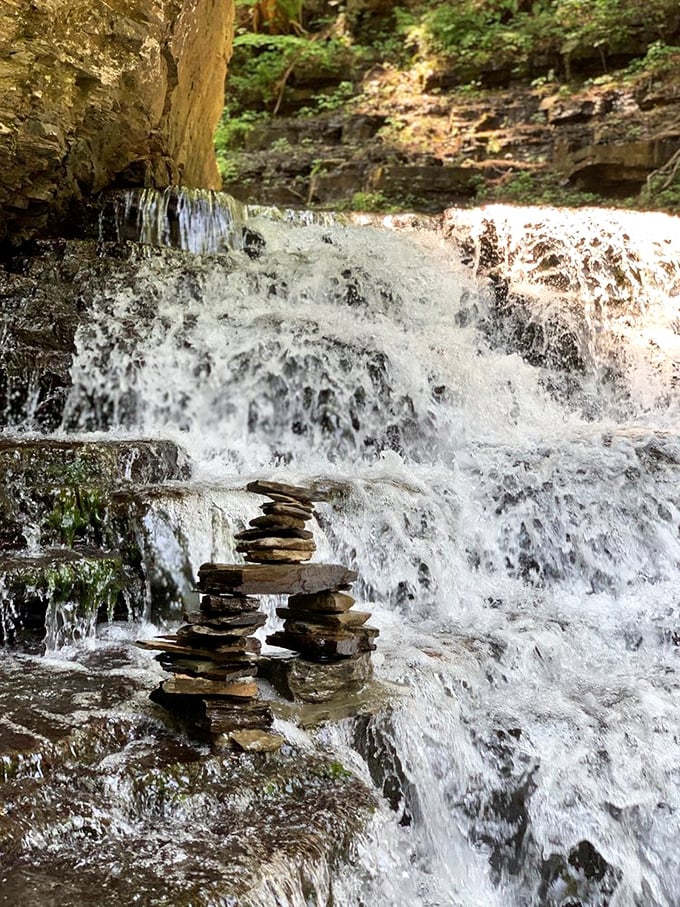 Mother Nature's balancing act. These carefully stacked stones stand as silent sentinels beside the rushing waters, proof that visitors find magic worth marking.