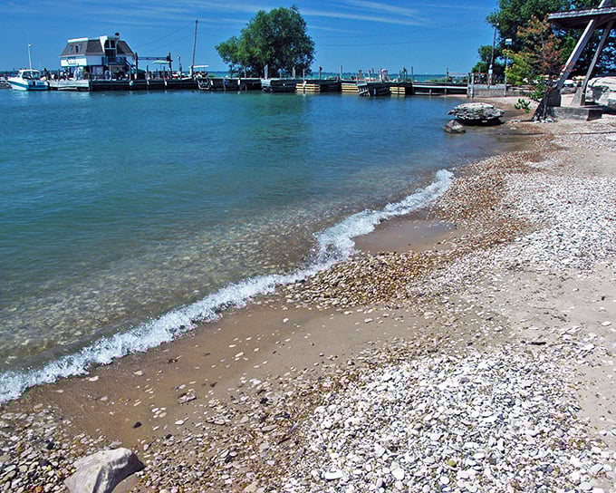 Where boats meet beach. The gentle waves of Lake Erie lap against the colorful shoreline, creating a soothing soundtrack for island adventurers.