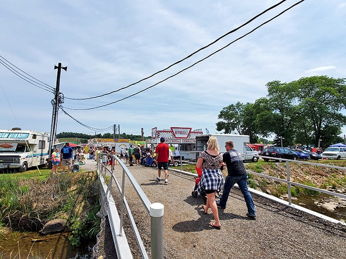 The pathway to bargain paradise. Visitors stream toward food vendors and market stalls, each step bringing them closer to unexpected finds.