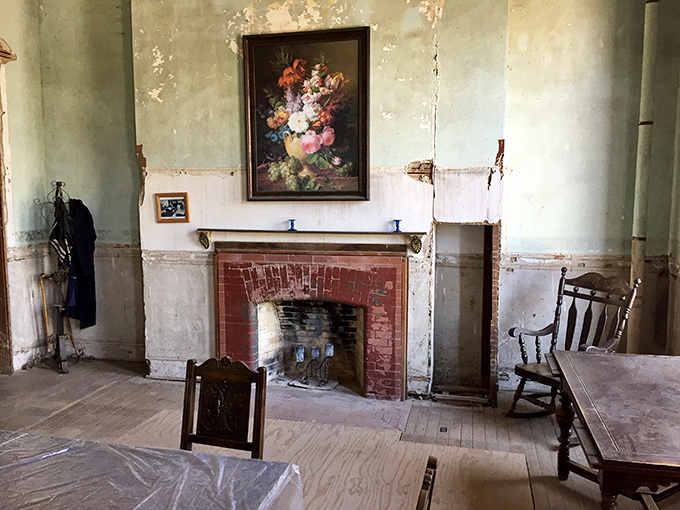 Time stands still in this forgotten parlor where a faded floral painting hangs above a simple brick fireplace&mdash;silent witness to decades of history and countless untold stories.