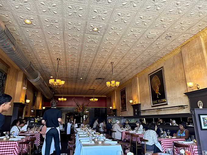 Beneath ornate tin ceilings and warm lighting, diners enjoy a slice of Paris where checkered tablecloths declare "serious French food happens here."