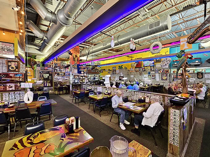 Dollar bills cling to walls like maritime wallpaper while neon lights illuminate decades of collected memories in this seafood shrine's gloriously chaotic interior.