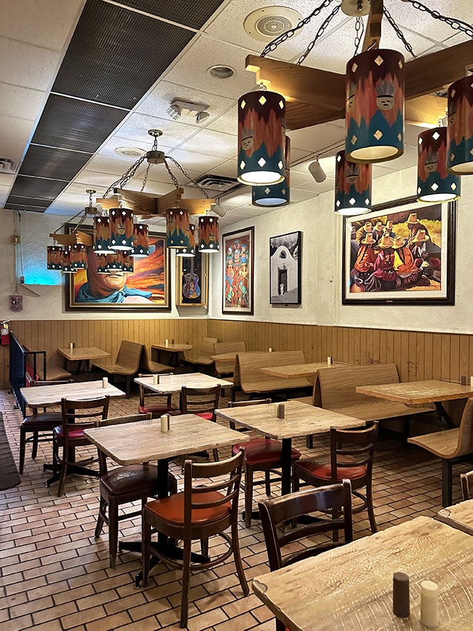 Southwestern pendant lights cast a warm glow over wooden tables while local artwork transforms a simple meal into a cultural experience.