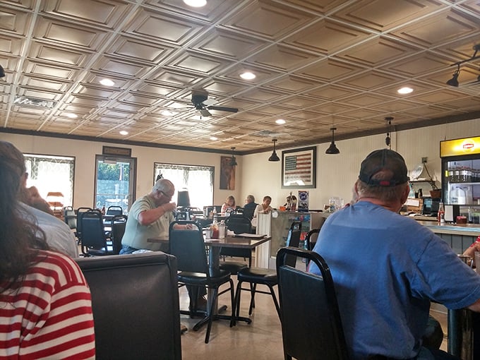Inside, the classic tin ceiling and comfortable booths create that perfect small-town atmosphere where conversations flow as freely as the coffee.