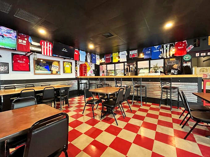 Soccer jerseys line the walls while the iconic red and white checkered floor screams "authentic British chippy" louder than a Premier League announcer.