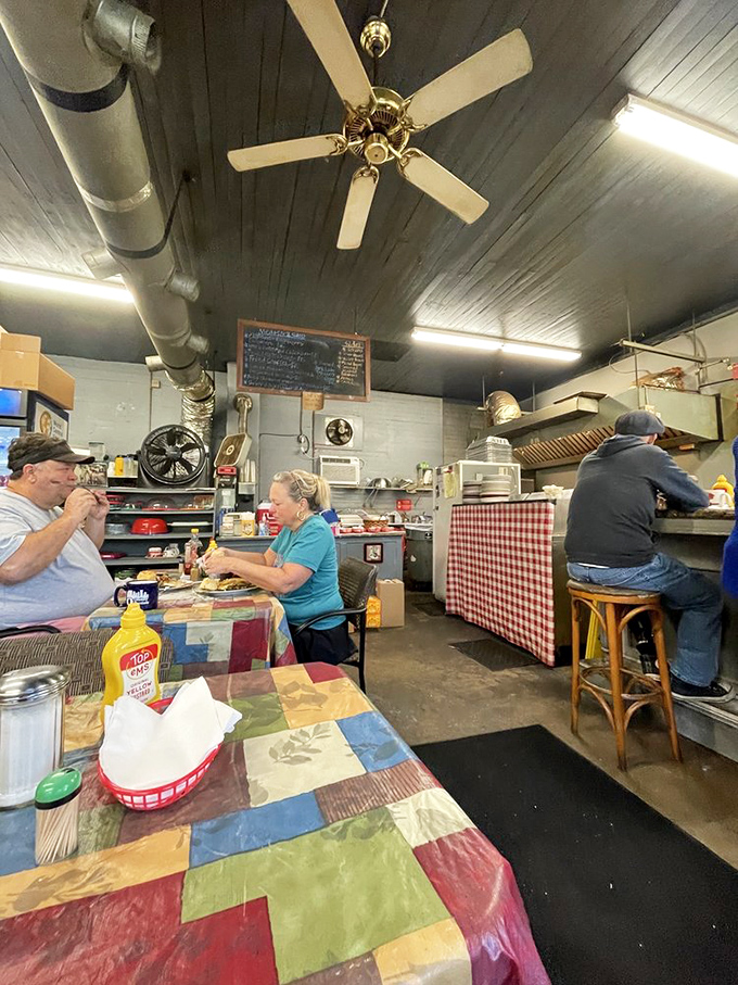 Inside, ceiling fans spin lazily above patchwork tablecloths while diners focus on what truly matters: the extraordinary food on their plates.