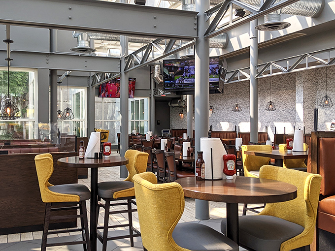 Industrial chic meets comfort food haven. Those mustard-yellow chairs aren't just stylish; they're strategically colored to hide the inevitable sauce drippings.