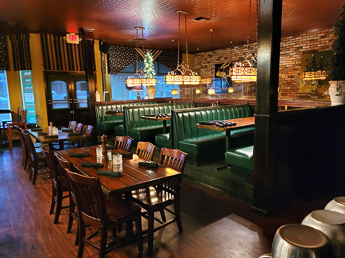 The dining room whispers "stay awhile" with its emerald booths, warm wood tones, and brick walls that could tell a thousand pasta stories.
