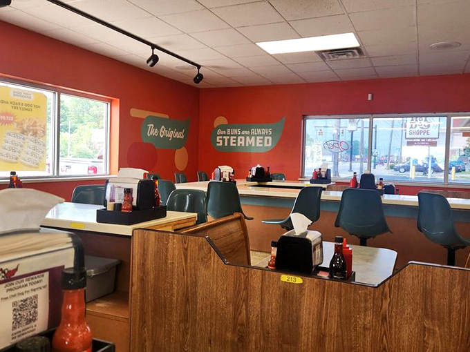 Step inside where wood-paneled booths and red walls create the perfect backdrop for serious hot dog conversations.