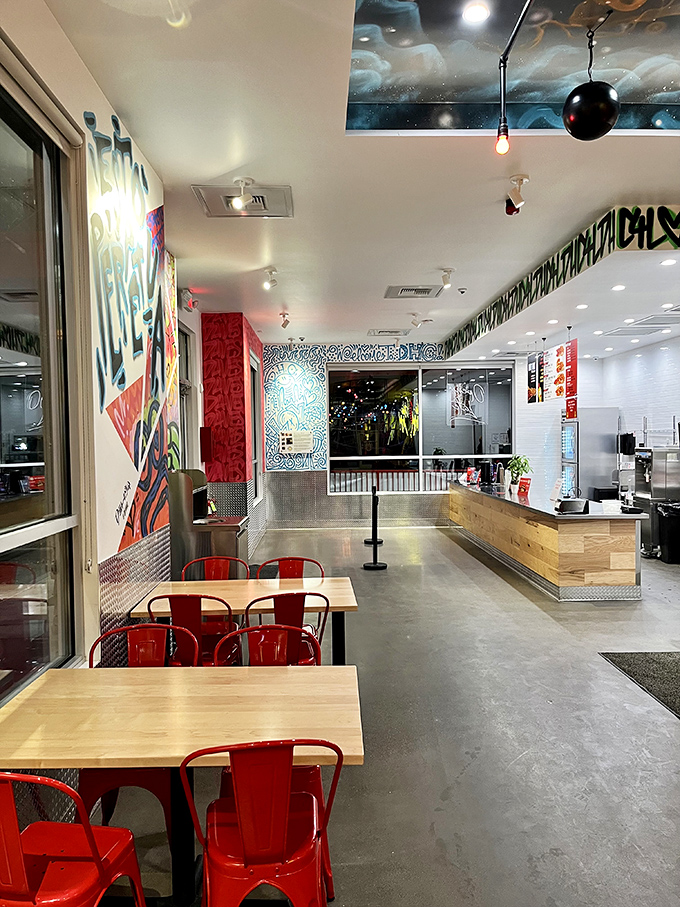 The sleek interior balances modern industrial elements with splashes of street art, creating a space that's as cool as the chicken is hot.