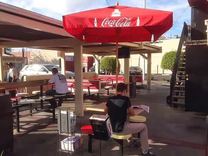 Simplicity reigns supreme under the Coca-Cola umbrellas. This outdoor seating area transforms ordinary Tuesday lunches into mini California vacations.