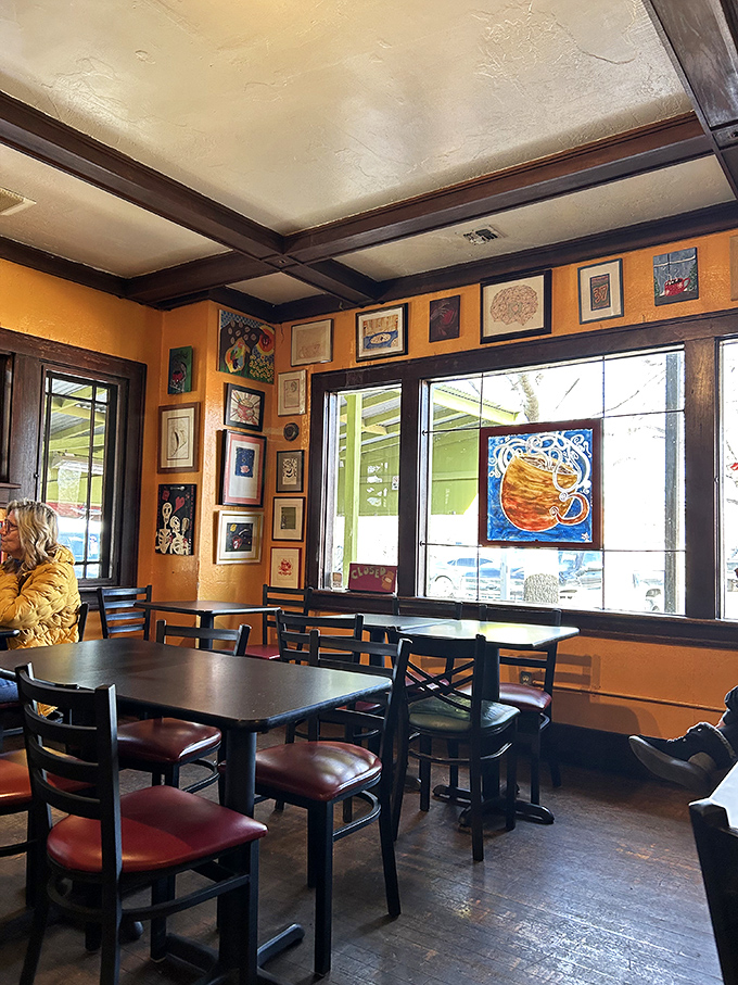 Warm orange walls adorned with local artwork create the perfect backdrop for morning conversations. It's like breakfast in an art gallery, but with better coffee.