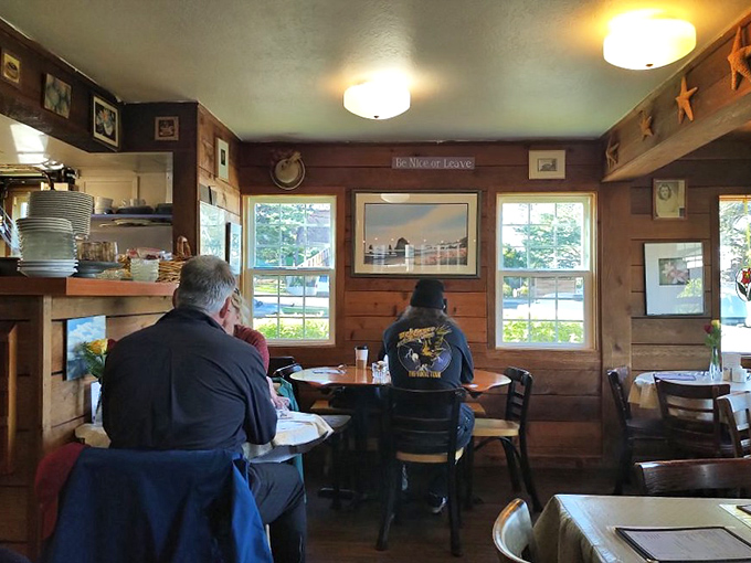 Knotty pine walls adorned with coastal art create the perfect backdrop for morning conversations and coffee refills.