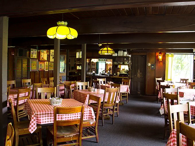 Classic red-checkered tablecloths and warm wood paneling set the stage for comfort food theater where chicken plays the starring role.