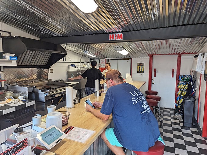 The classic checkered floor and corrugated metal ceiling create that perfect "no-frills" atmosphere where culinary greatness often hides.