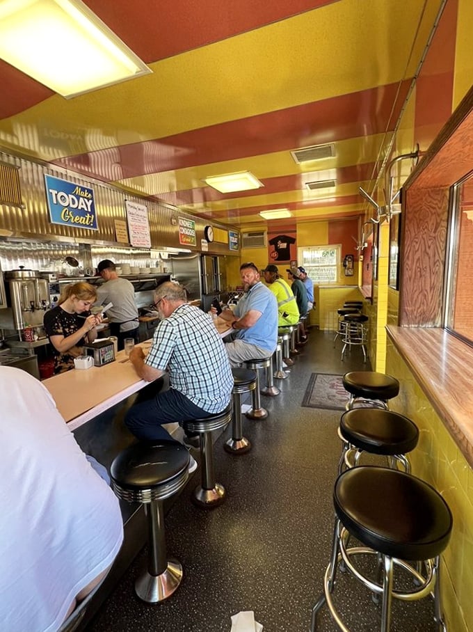 The yellow and red striped ceiling feels like a circus tent of comfort food where everyone gets front-row seats to the breakfast show.