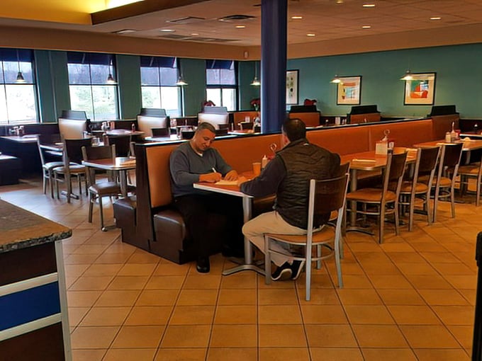 Classic diner ambiance with teal walls and comfortable booths creates that perfect "everybody knows your name" atmosphere where conversations flow as freely as the coffee.