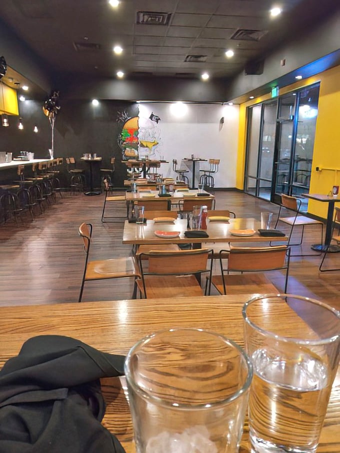 Modern minimalism meets burger paradise inside Joy Burgers, where the black and yellow color scheme sets the stage for the real stars&mdash;those magnificent patties.