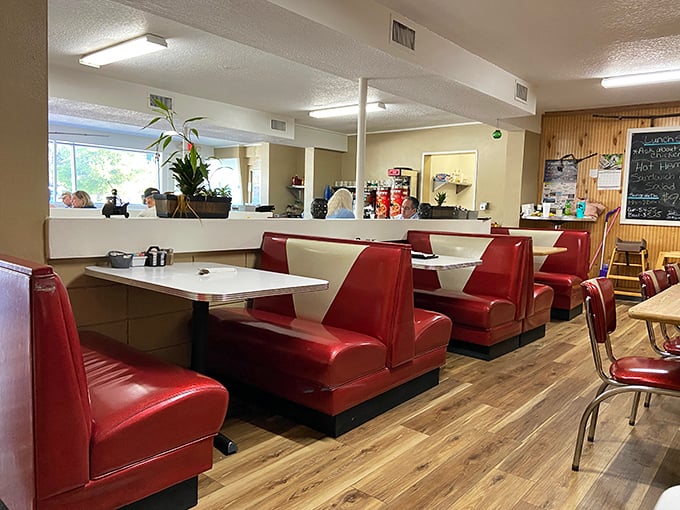 Classic red vinyl booths and warm wood floors create that perfect small-town diner atmosphere where conversations flow as freely as the coffee.