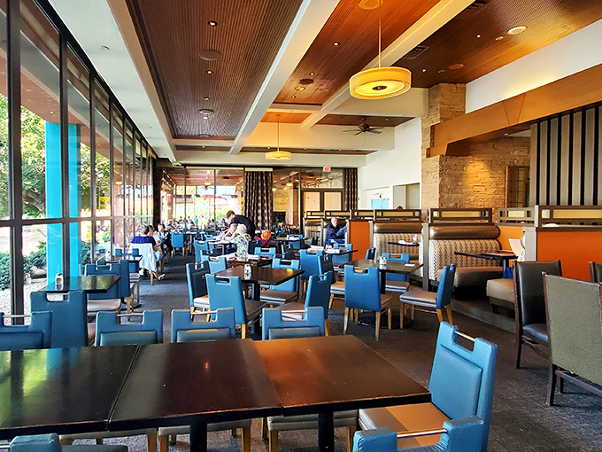 The modern interior balances upscale design with comfort, those distinctive blue chairs adding a pop of color that somehow makes everything taste better.