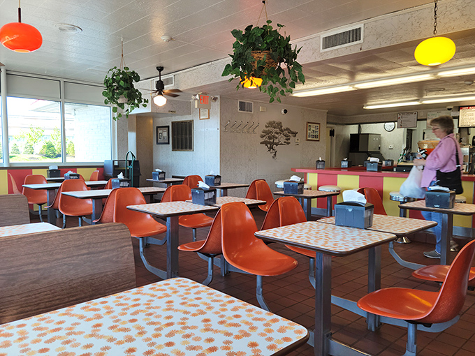 Step inside this retro wonderland where orange chairs and checkered tables create pure nostalgic magic.