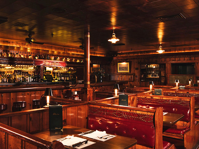 Wood-paneled walls, red leather booths, and soft lighting create the kind of atmosphere where Don Draper would feel perfectly at home ordering a Manhattan.