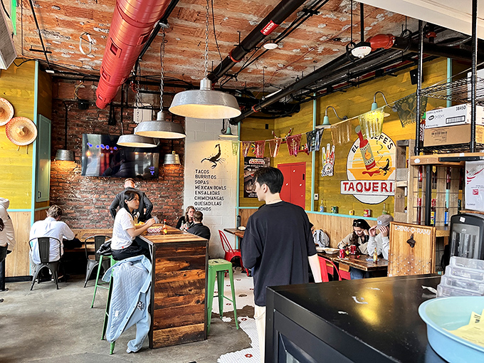 Industrial chic meets taco joint authenticity with exposed brick walls, hanging lights, and wooden tables where culinary magic happens daily.