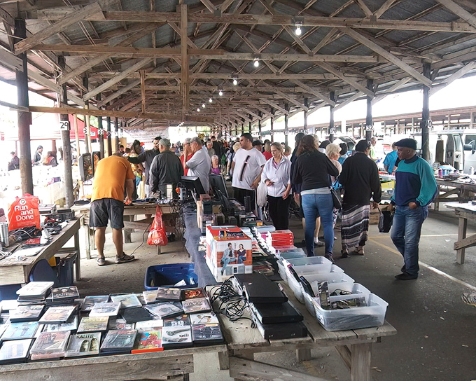 Treasure hunters scan tables under rustic wooden beams. This isn't just shopping&mdash;it's an archaeological expedition where the artifacts come with price tags.