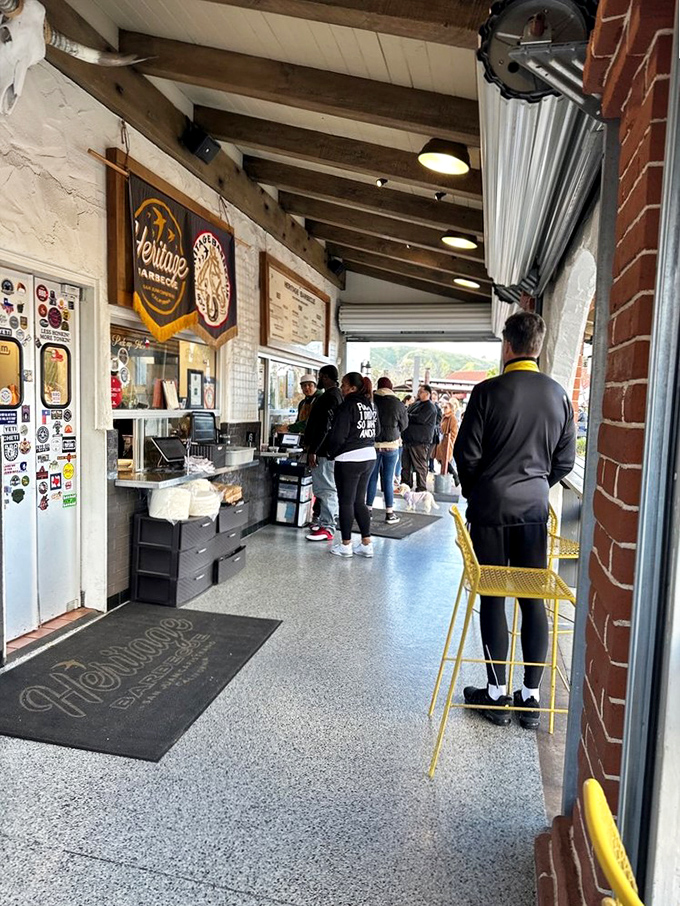 The anticipation is half the fun. Inside, hungry patrons queue beneath wooden beams, their patience about to be rewarded with smoky perfection.