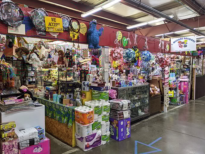 Piñatas hang like colorful sentinels guarding treasures below. This booth's eclectic mix of toys, household goods, and whimsy is typical Treasure Aisles magic.