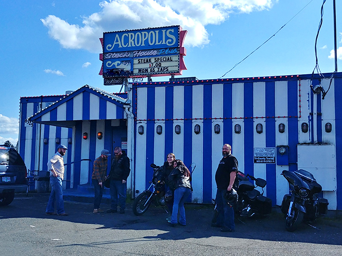 The Acropolis's blue-and-white striped building stands out like a culinary beacon for steak lovers and motorcycle enthusiasts alike.