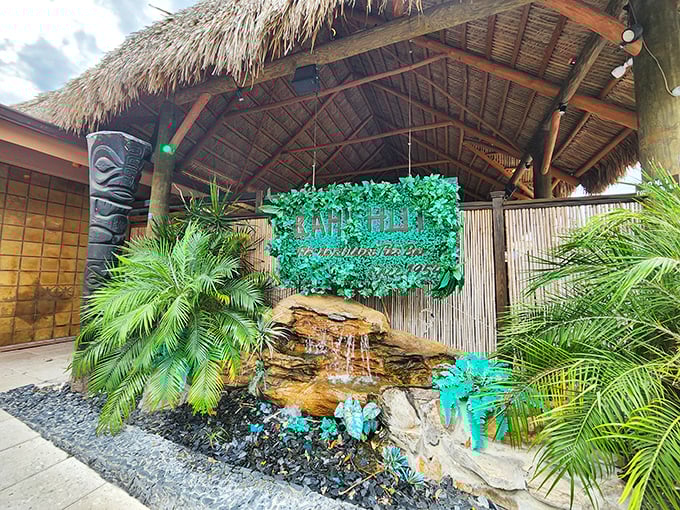 Tiki temple entrance that whispers, "Your rum-soaked adventure begins here." The stone waterfall sets the mood for liquid escapism.