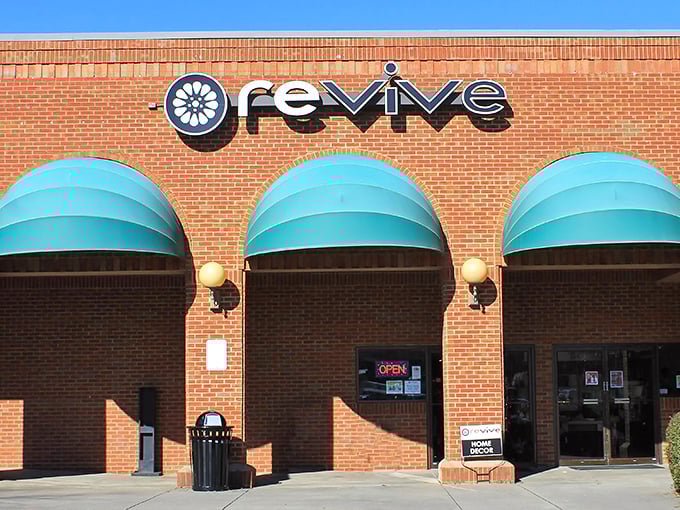 Those turquoise awnings aren't just pretty—they're beacons for bargain hunters! Revive Consignment's brick facade houses countless design treasures waiting to be discovered.