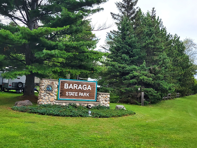 The welcoming entrance to Baraga State Park promises adventure among towering pines and crystal-clear waters of the Upper Peninsula.