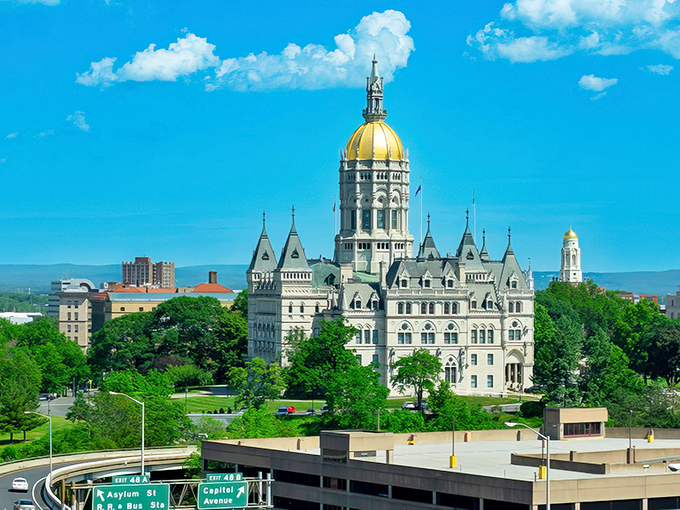 The gold-domed State Capitol building stands majestically against a brilliant blue sky, Hartford's crown jewel since 1878.