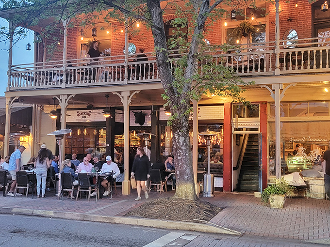 Evening diners enjoy the magical ambiance of Little Alley, where string lights and Southern hospitality elevate every bite.